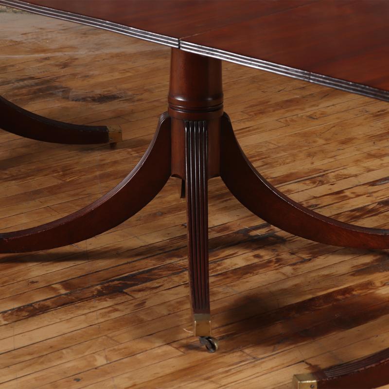 A thirteen foot triple pedestal mahogany dining table with leaves circa ...