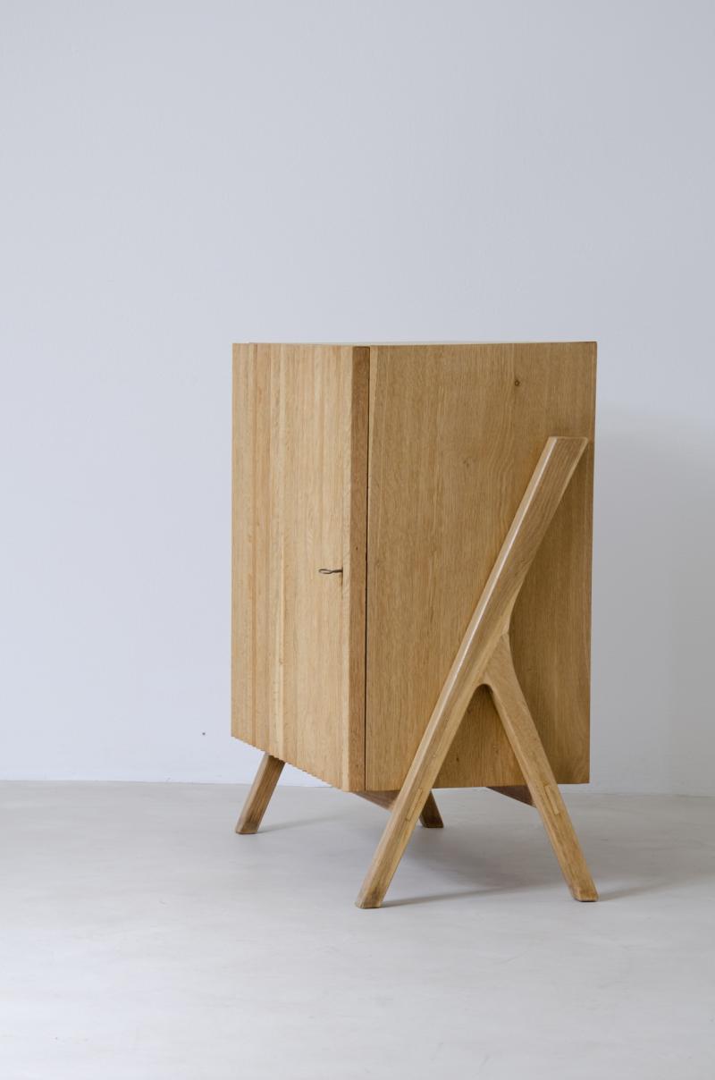 Small storage unit in light oak with ribbed wood front.