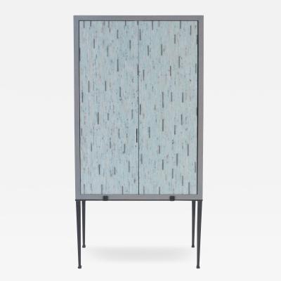 A stylish custom-made cerused oak cabinet with mosaic glass doors.