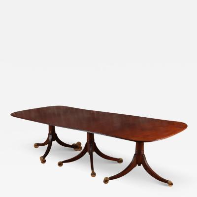A thirteen foot triple pedestal mahogany dining table with leaves circa ...