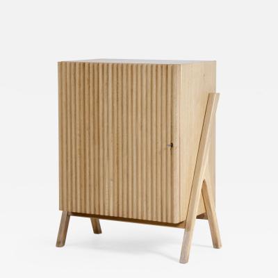 Small storage unit in light oak with ribbed wood front.