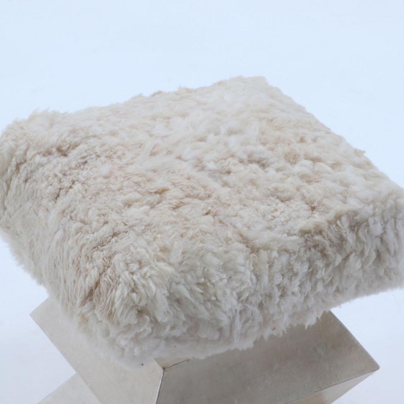 A Contemporary parchment covered stool having goat hair upholstery.