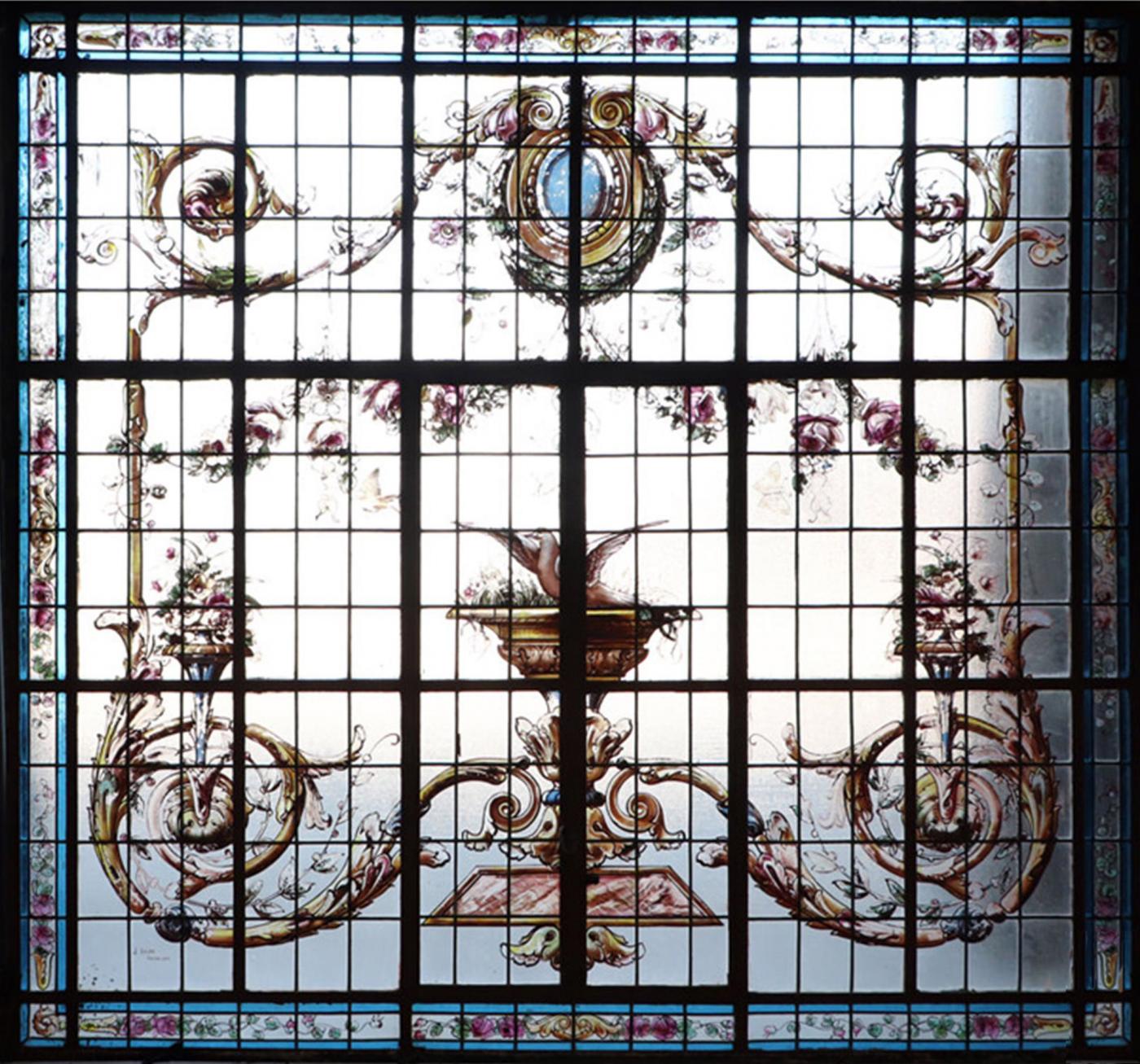 A large painted and leaded glass window in iron frame circa 1900.