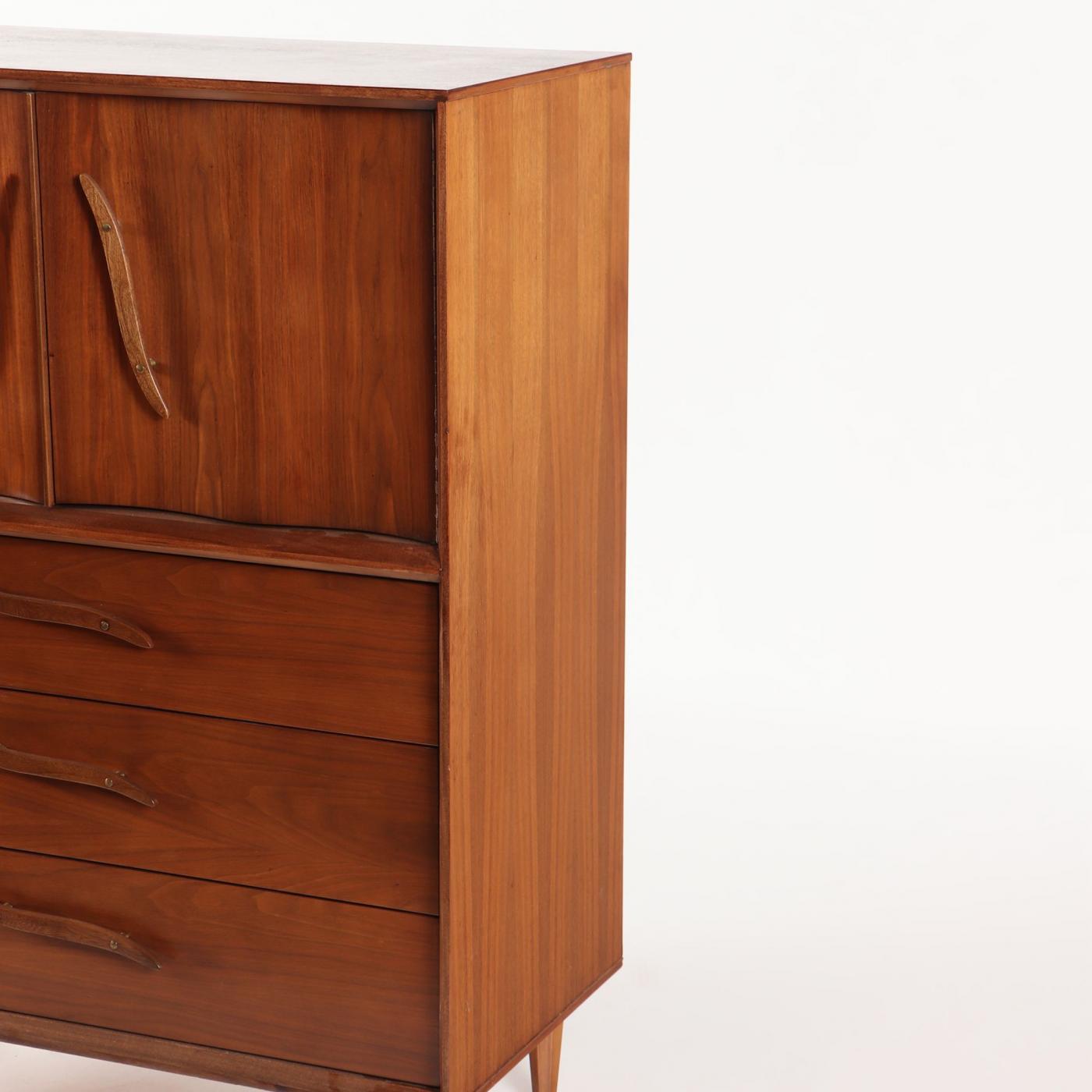 A mid century modern walnut highboy cabinet circa 1960.