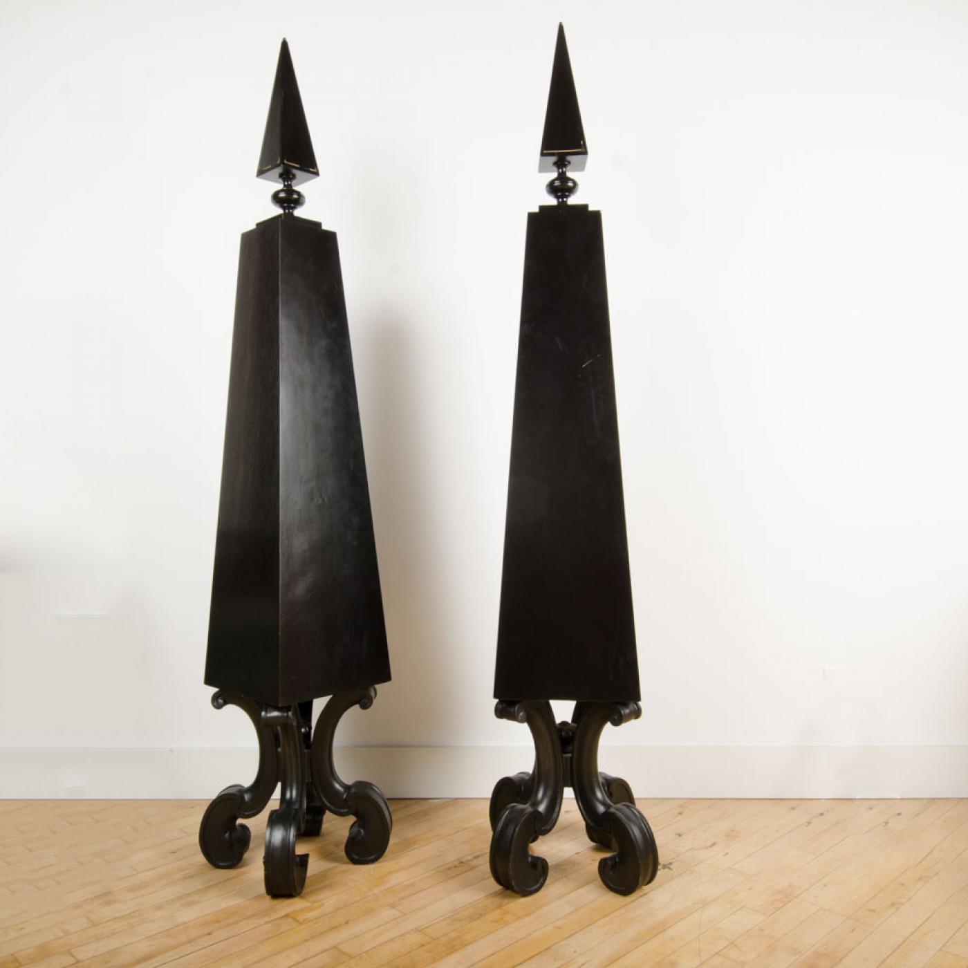 A pair of tall black decorative obelisks