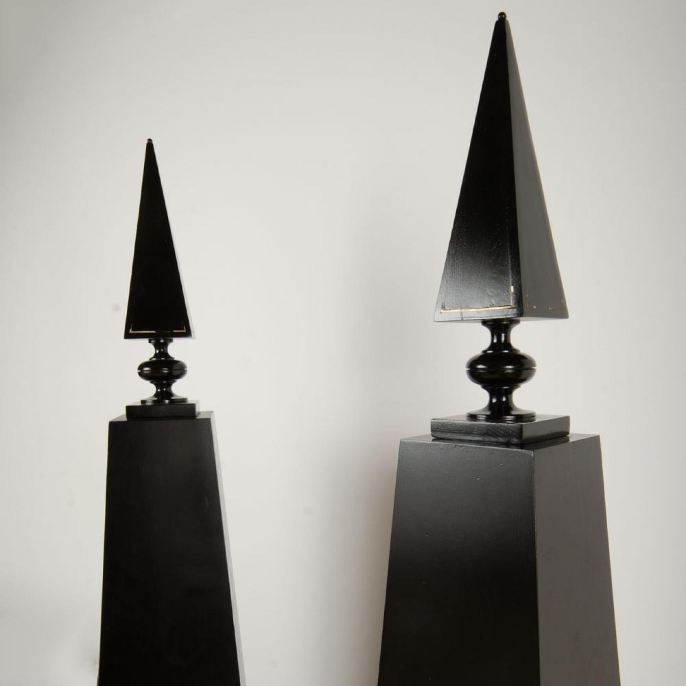 A pair of tall black decorative obelisks