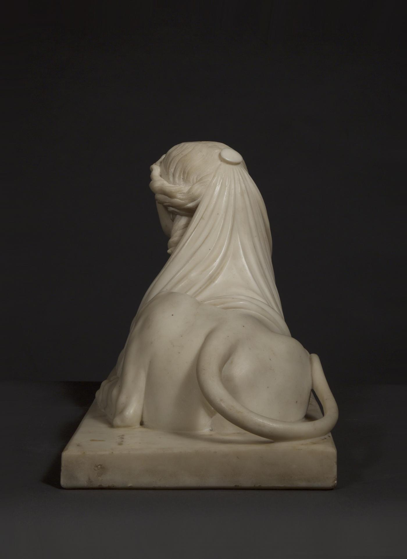 An Carved Statuary Marble Sculpture Of A Reclining Veiled Female Sphinx