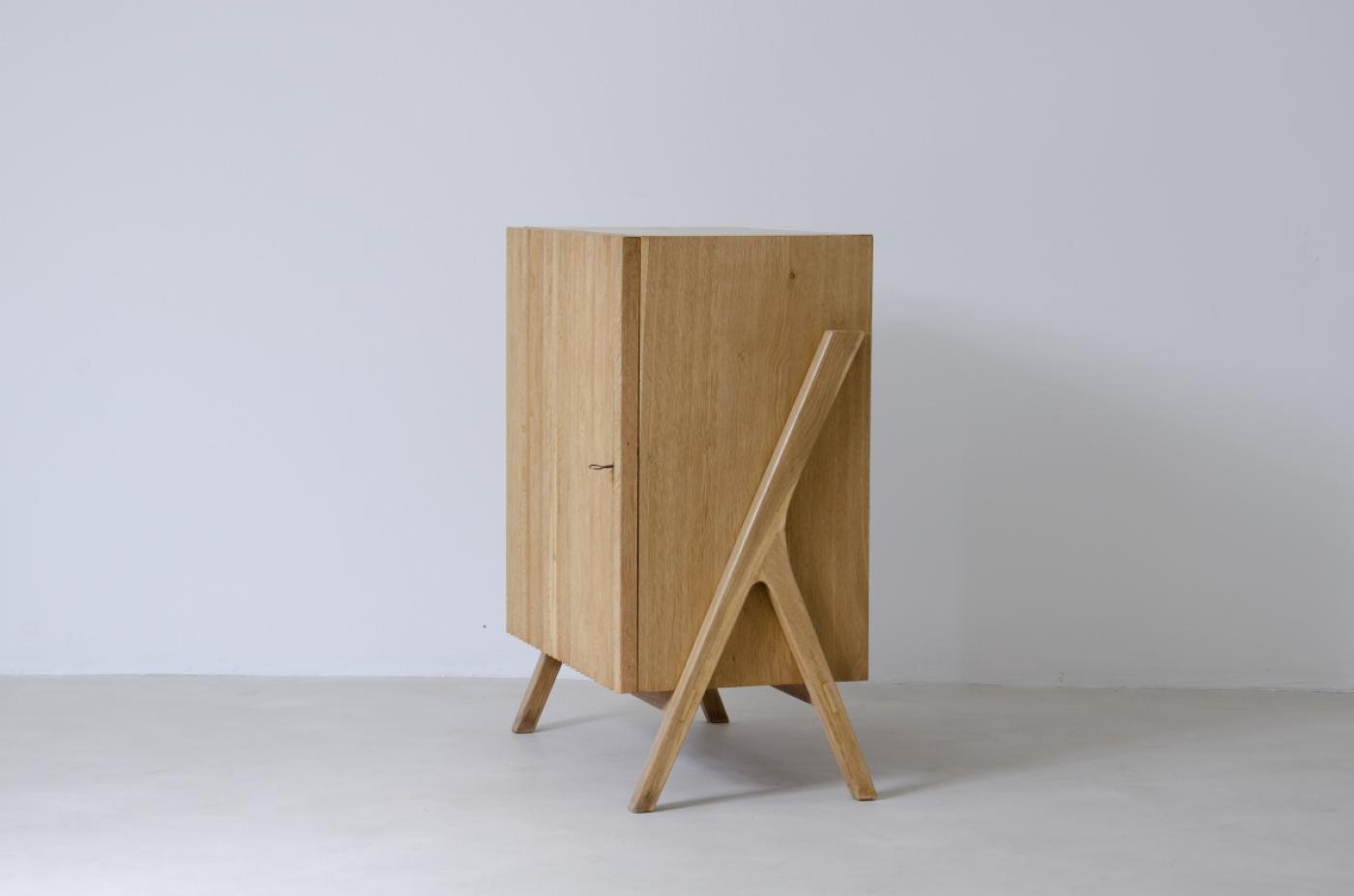 Small storage unit in light oak with ribbed wood front.