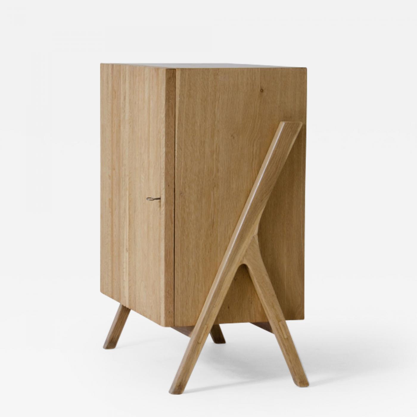 Small storage unit in light oak with ribbed wood front.